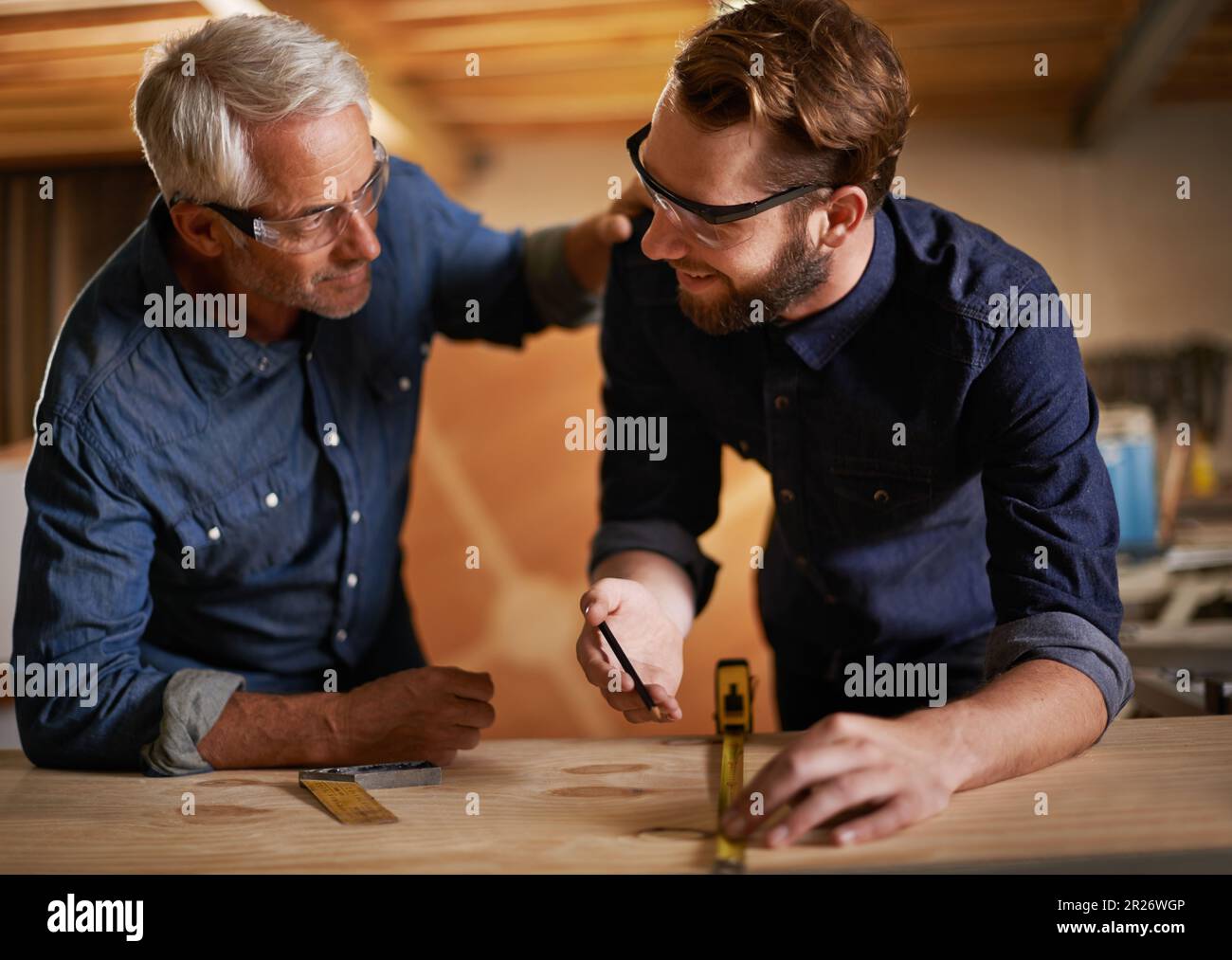 Am I doing this right. a father and son working together in a workshop ...