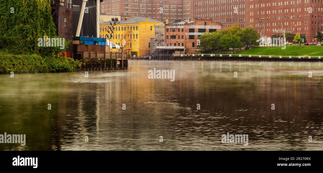 Early morning mist rises on a bend of the Cuyahoga river in downtown ...