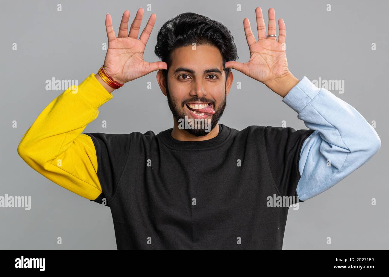 Comical funny young indian man making playful silly facial expressions ...