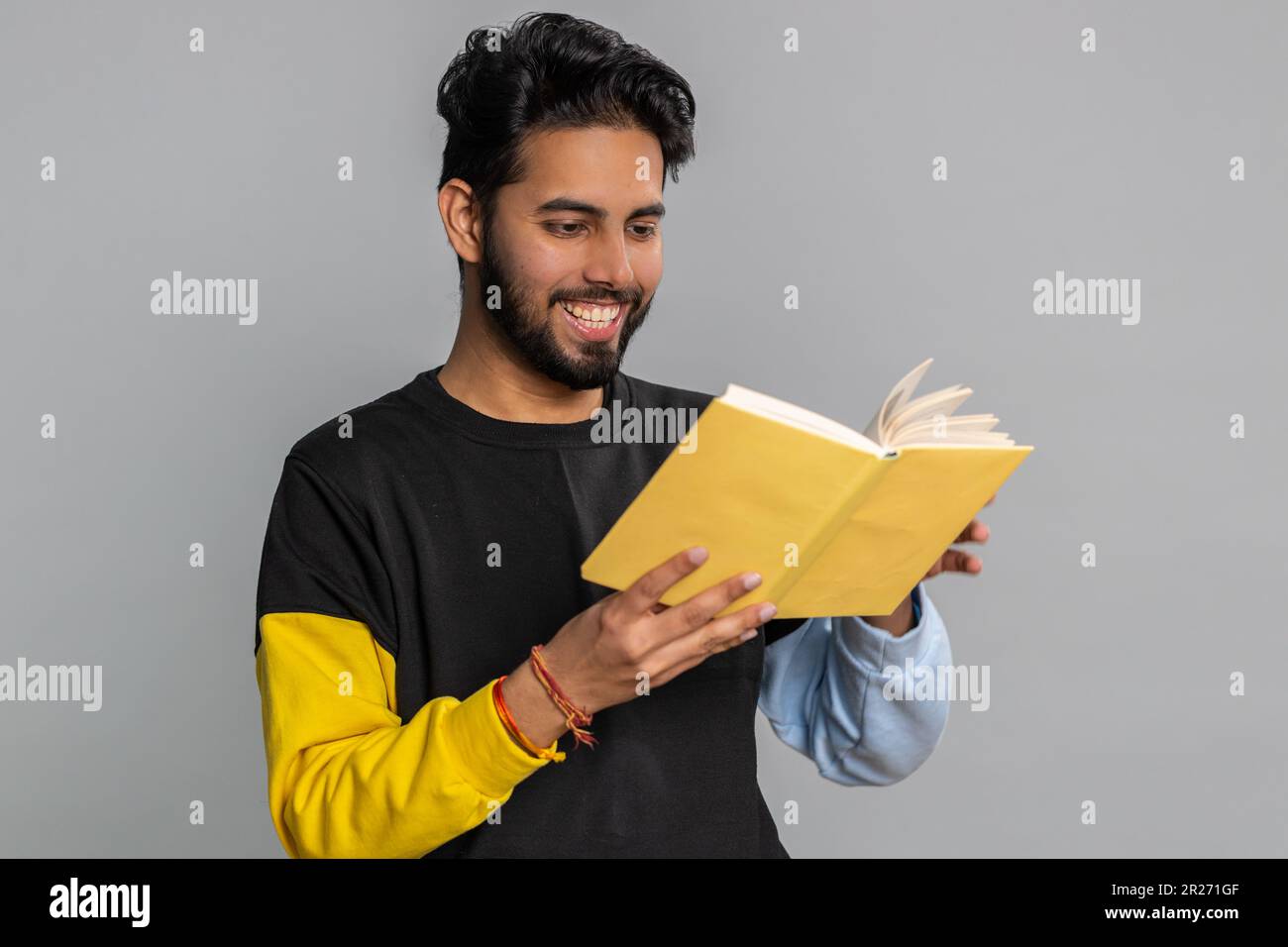 Happy indian man reading funny interesting fairytale story book ...