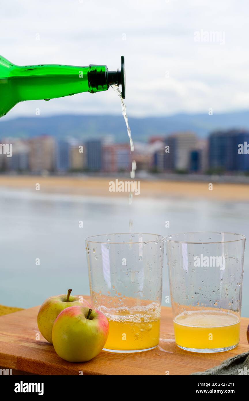 Pouring of natural Asturian cider made from fermented apples in wooden ...