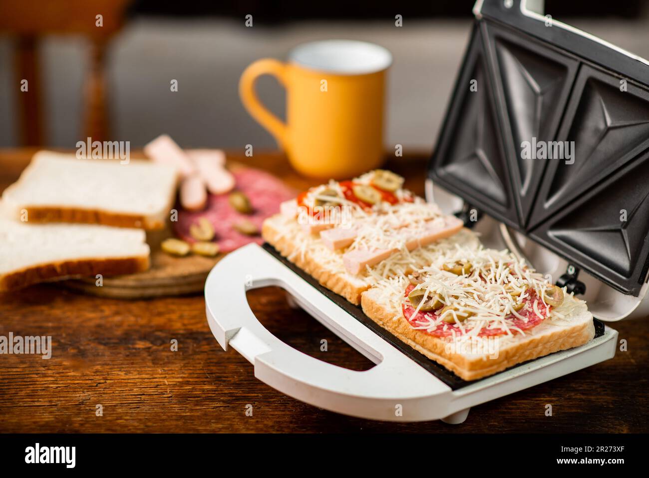 open sandwich maker with cheese toast and sausages. Sandwiching Stock ...