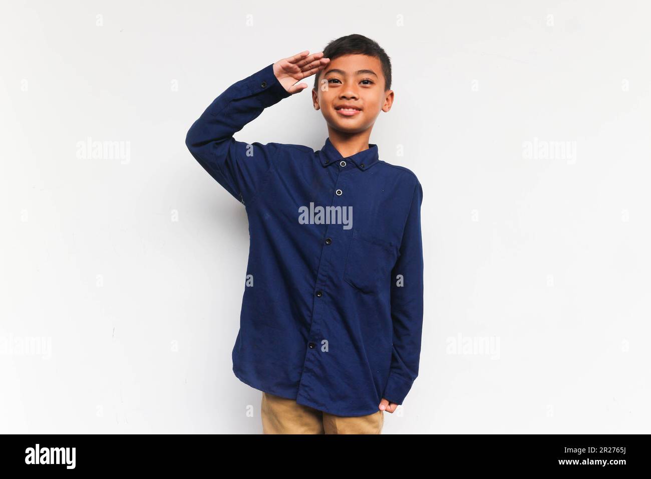 Happiness boy wearing blue casual shirt looking at camera while doing ...