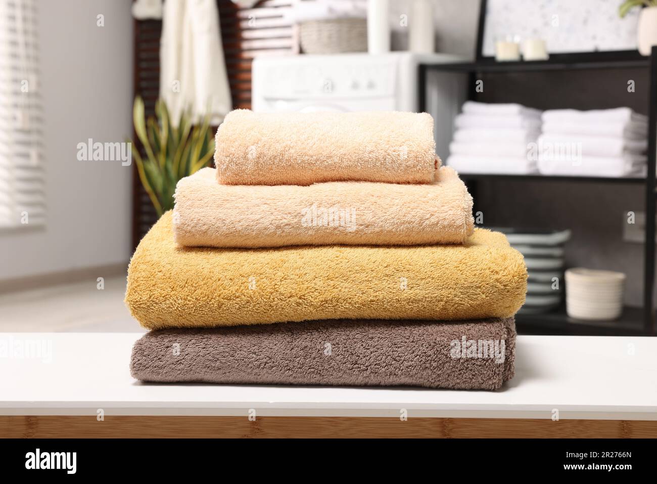 Stack of clean towels on white table in laundry room Stock Photo - Alamy