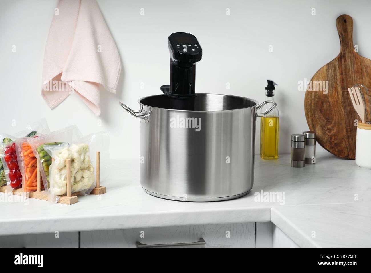 Pot with sous vide cooker and vacuum packed food products in kitchen ...