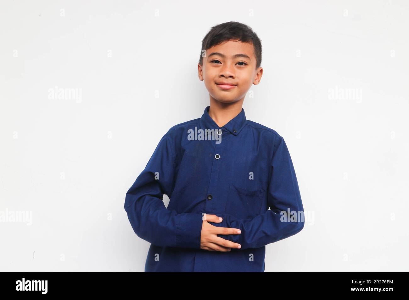 Smiling boy in blue shirt looking at the camera while put hands on the ...