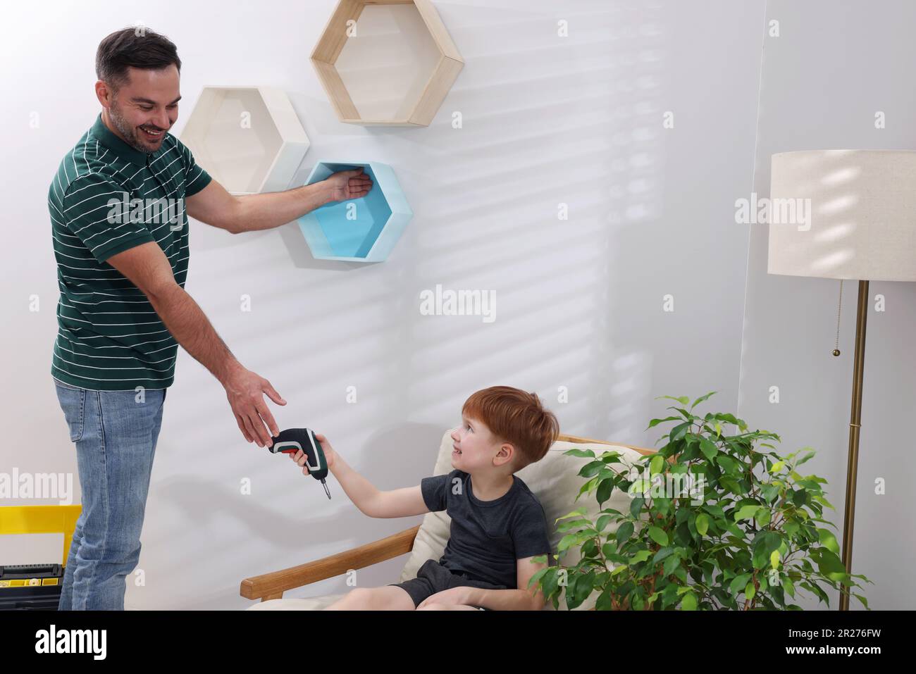 Son giving tool to father at home. Repair work Stock Photo - Alamy