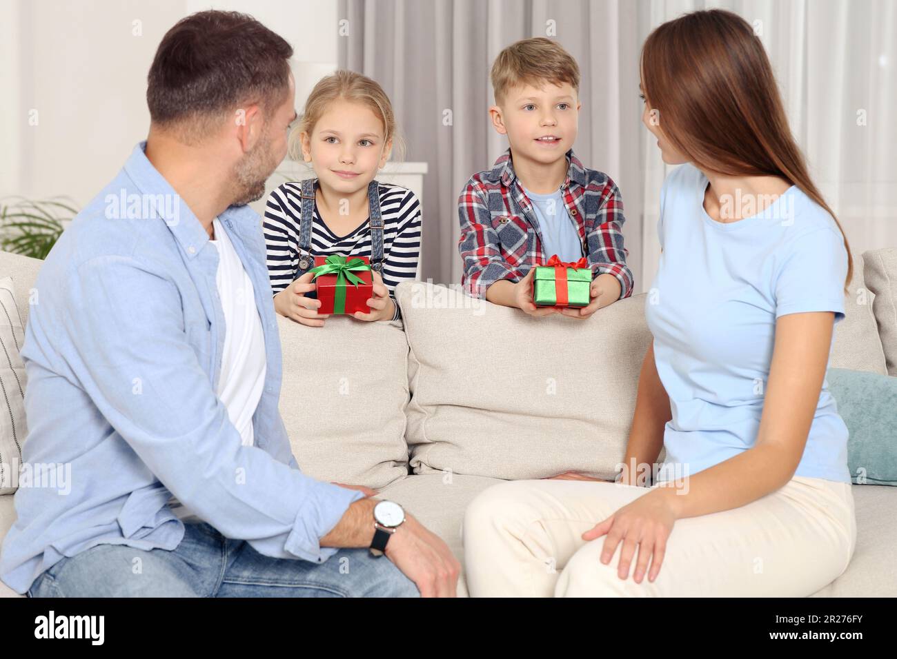 Little children presenting their parents with gifts at home Stock Photo ...