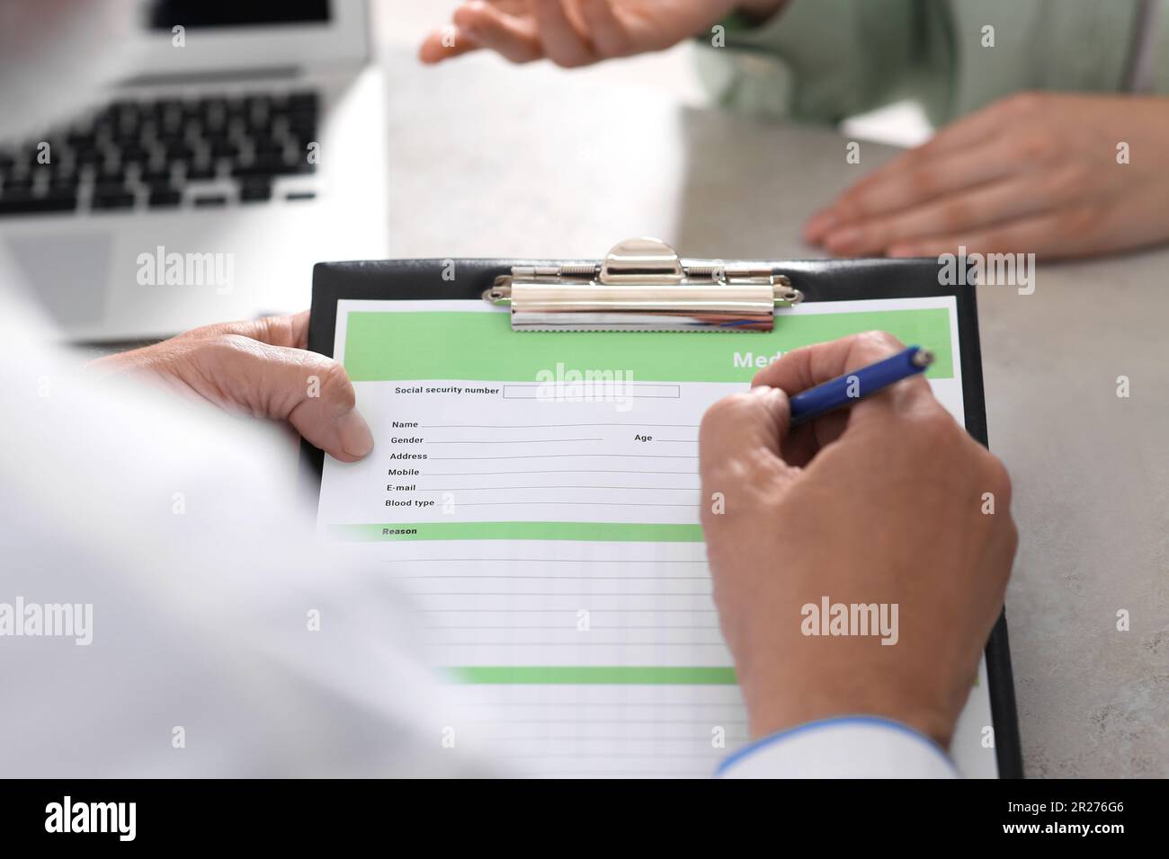 Mature doctor filling patients form hi-res stock photography and images ...