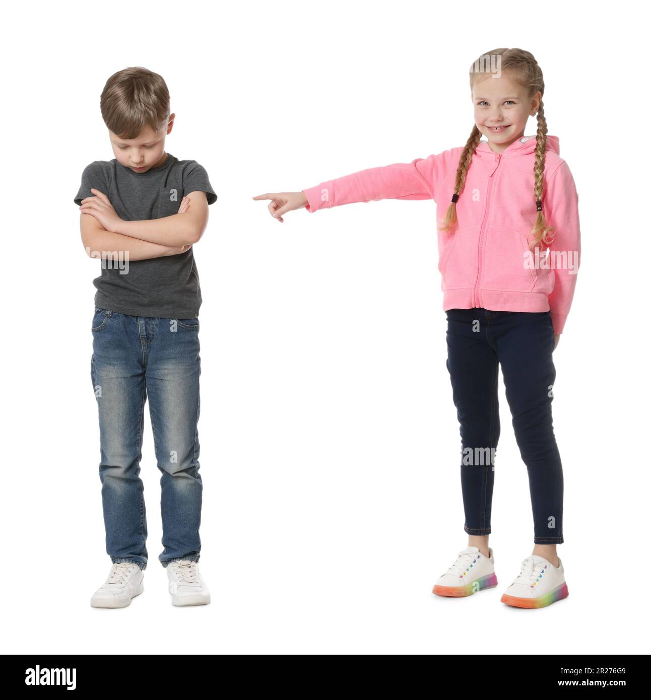 Girl laughing and pointing at upset boy on white background. Children's ...