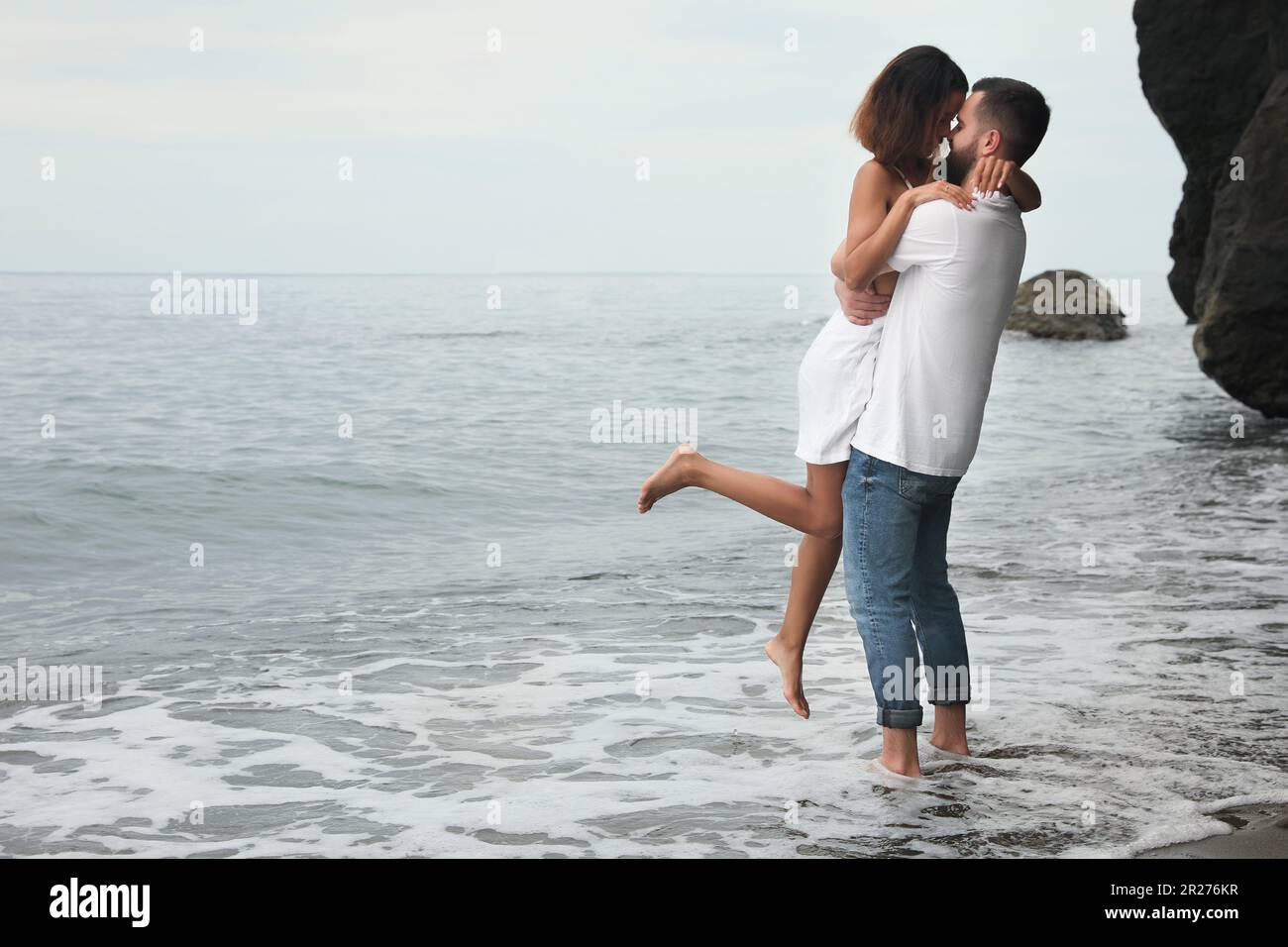 Young couple kissing on beach near sea. Space for text Stock Photo - Alamy