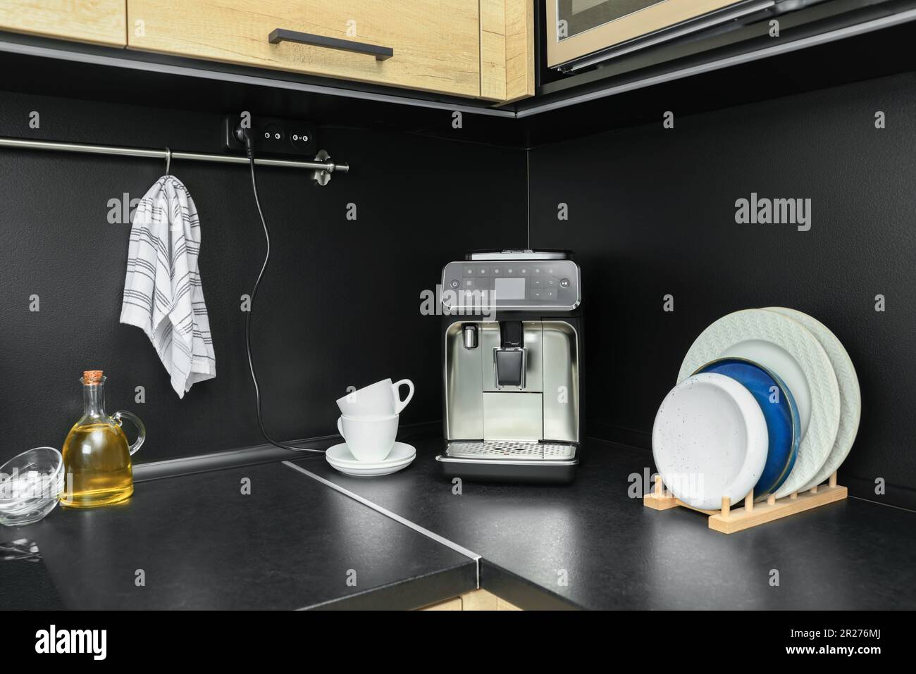 Coffee machine and kitchen utensils on black countertop Stock Photo - Alamy