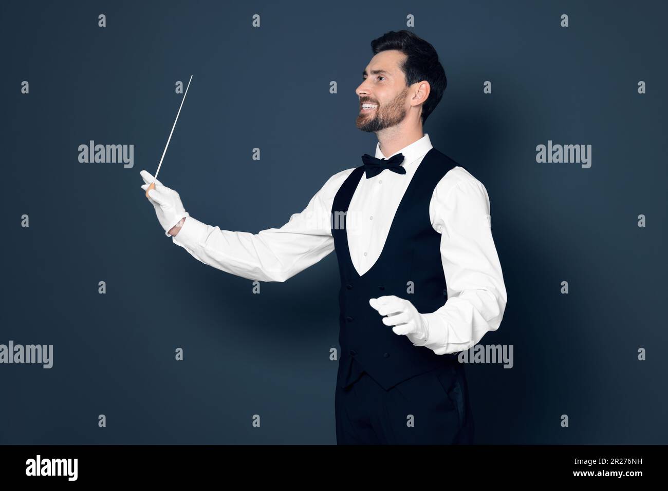 Happy professional conductor with baton on grey background Stock Photo ...