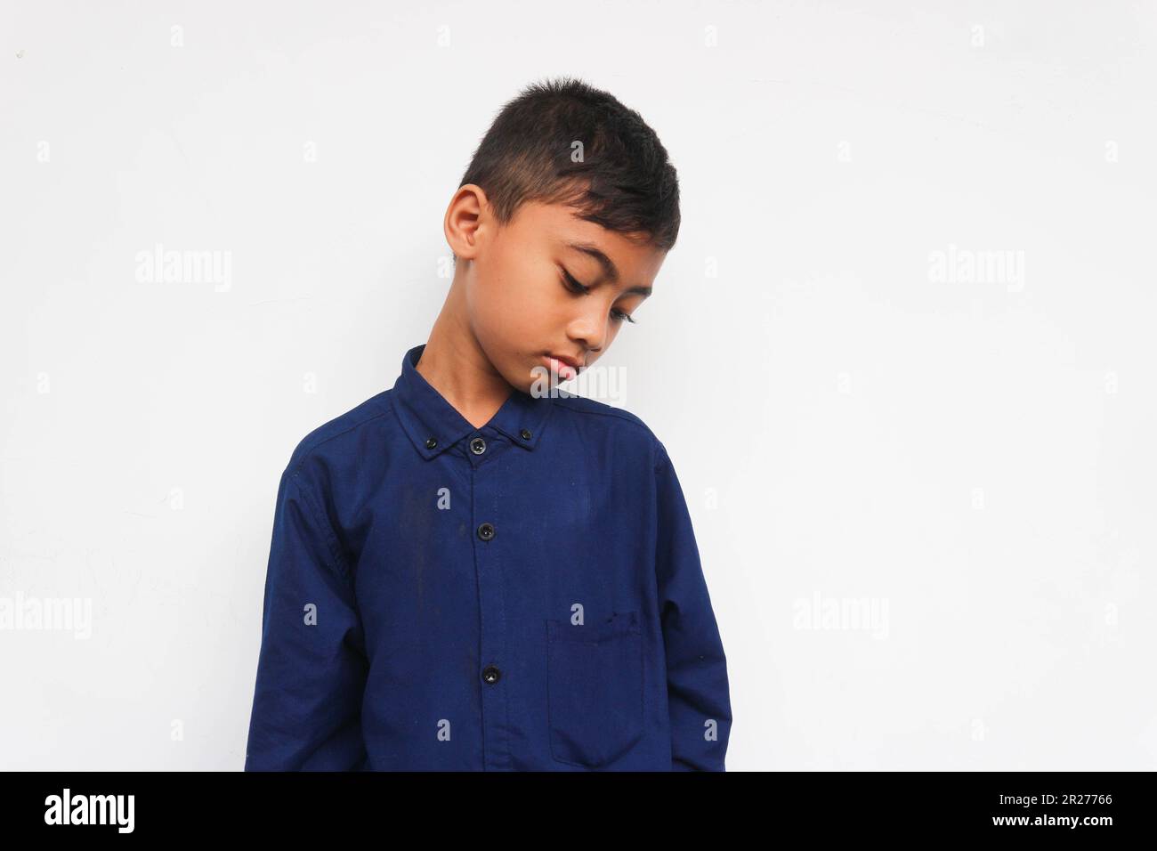 Sad boy wearing blue shirt isolated on white background Stock Photo - Alamy