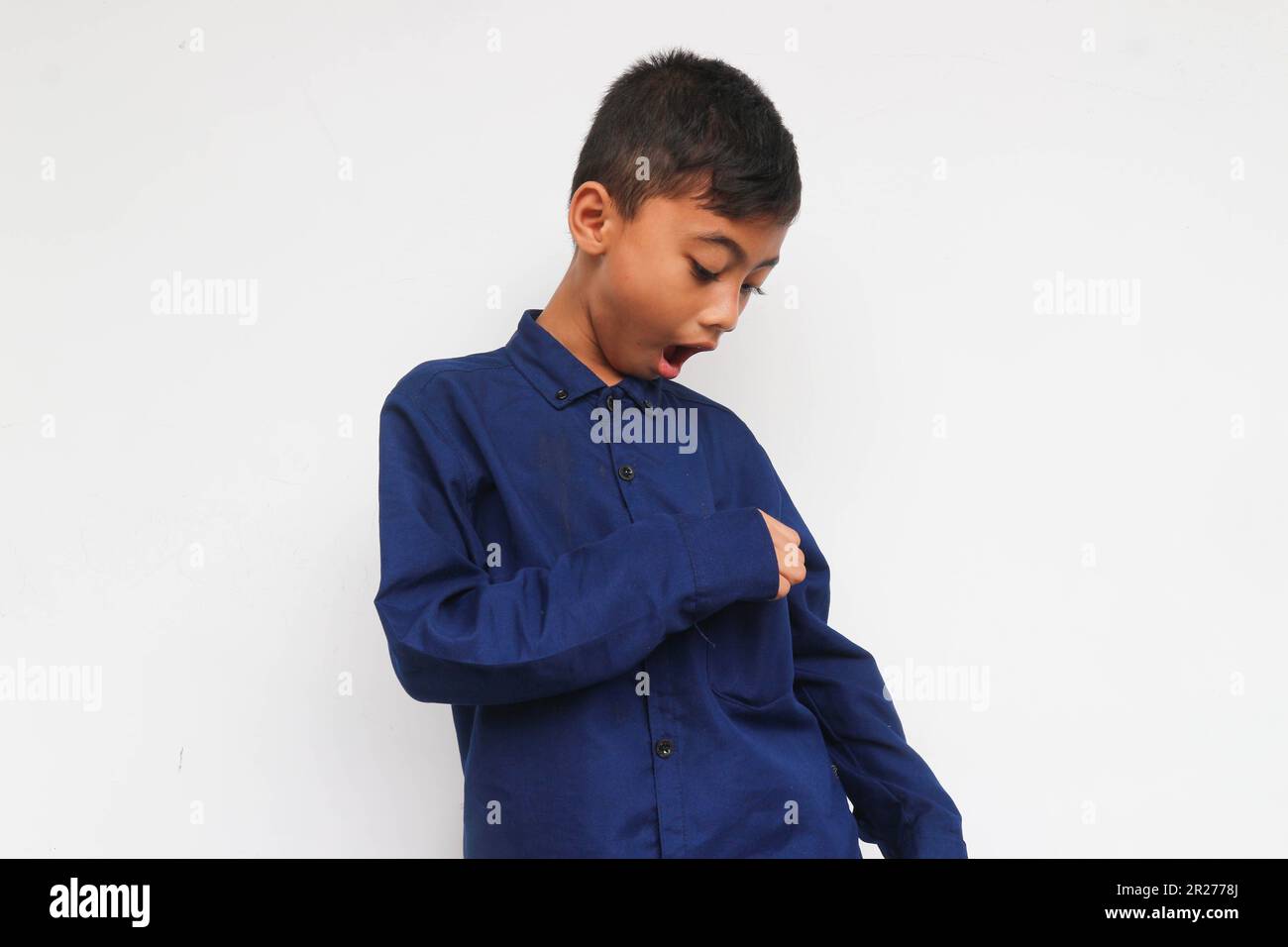 Surprised boy looking on to his pocket on a shirt , looks he found ...