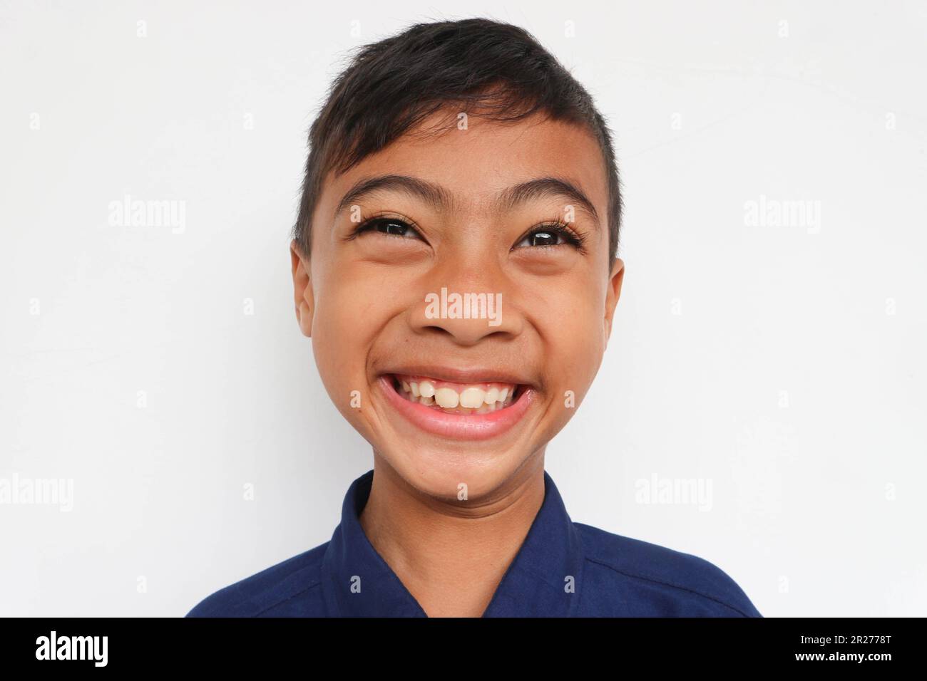 Close up of Cheerful little boy in express funny face, isolated on white background. A 10 years ...