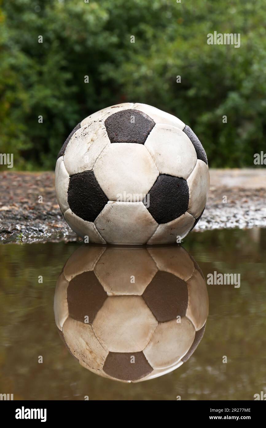 Dirty soccer ball in muddy puddle outdoors Stock Photo - Alamy