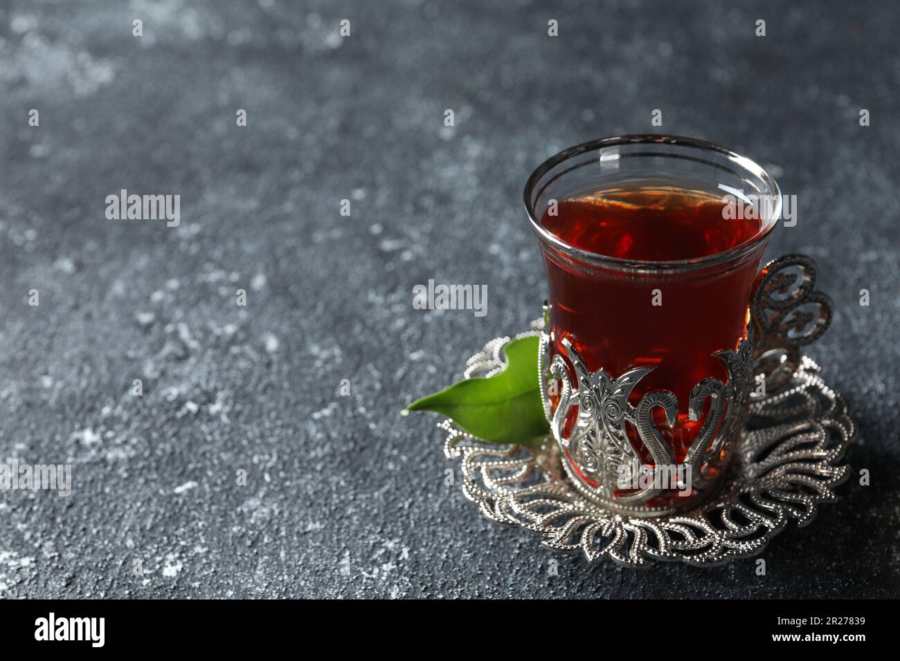Glass of traditional Turkish tea in vintage holder on grey textured ...