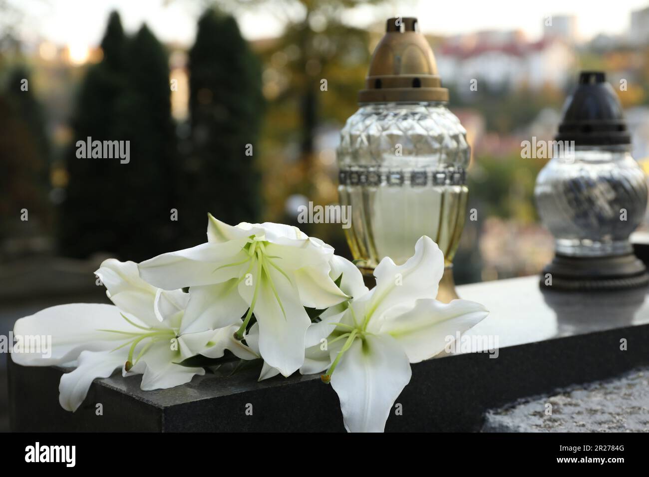 White lilies and grave lights on granite tombstone outdoors. Funeral ceremony Stock Photo - Alamy