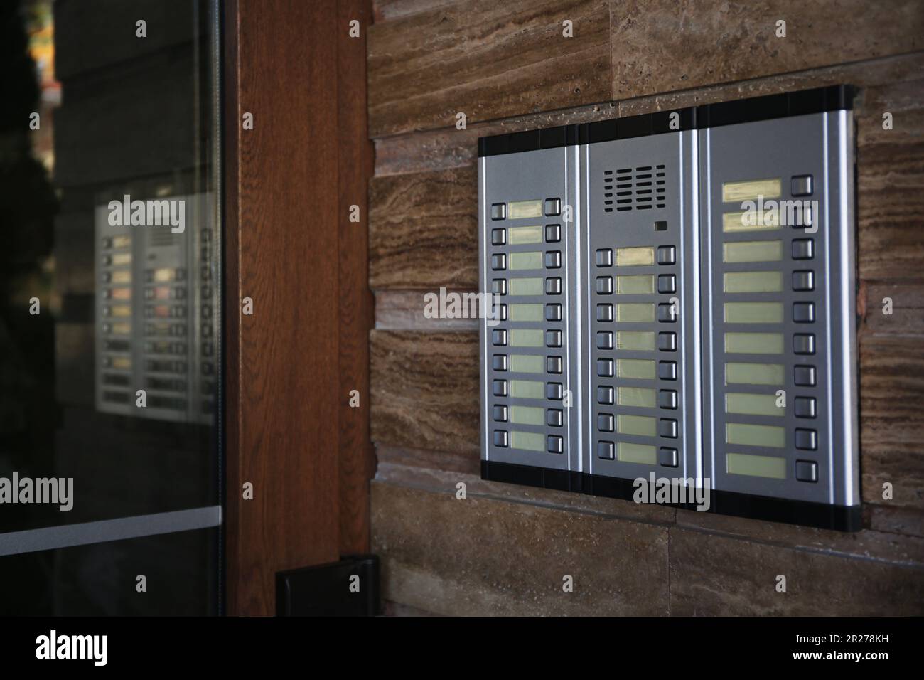 Modern intercom system on stone wall, space for text. House security ...