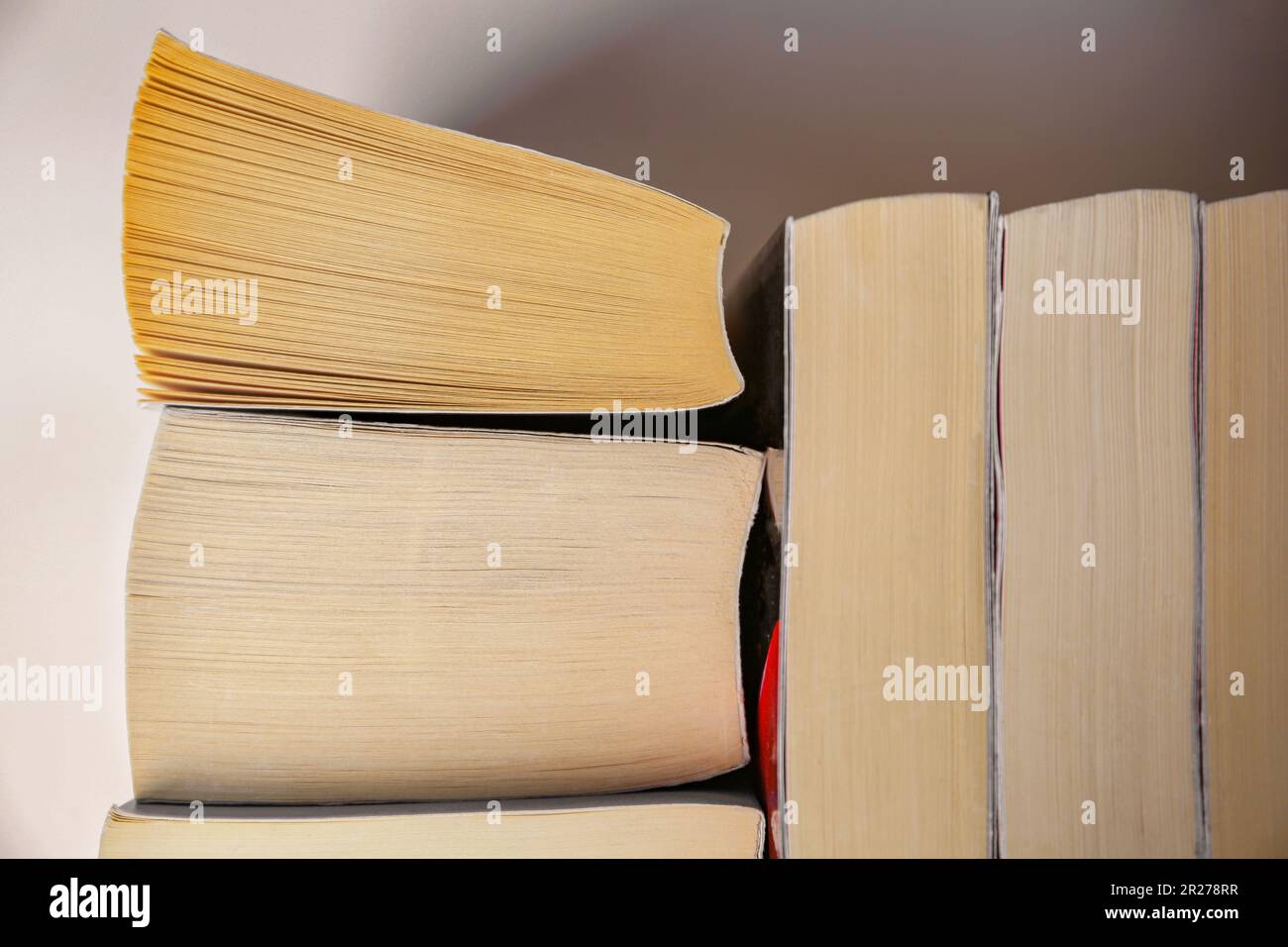Collection of different books near white wall, closeup Stock Photo - Alamy