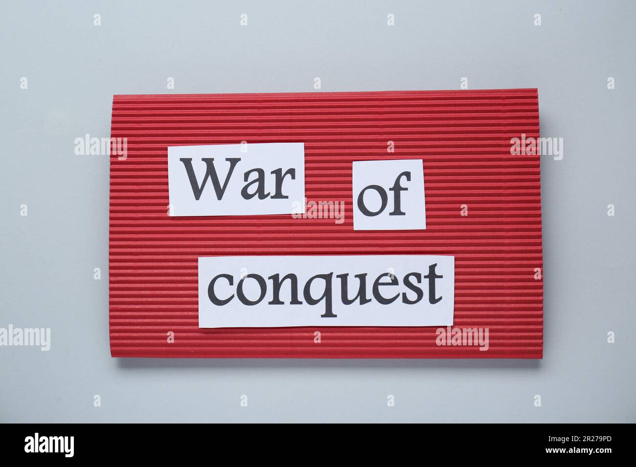 Red paper with words War Of Conquest on white background, top view ...
