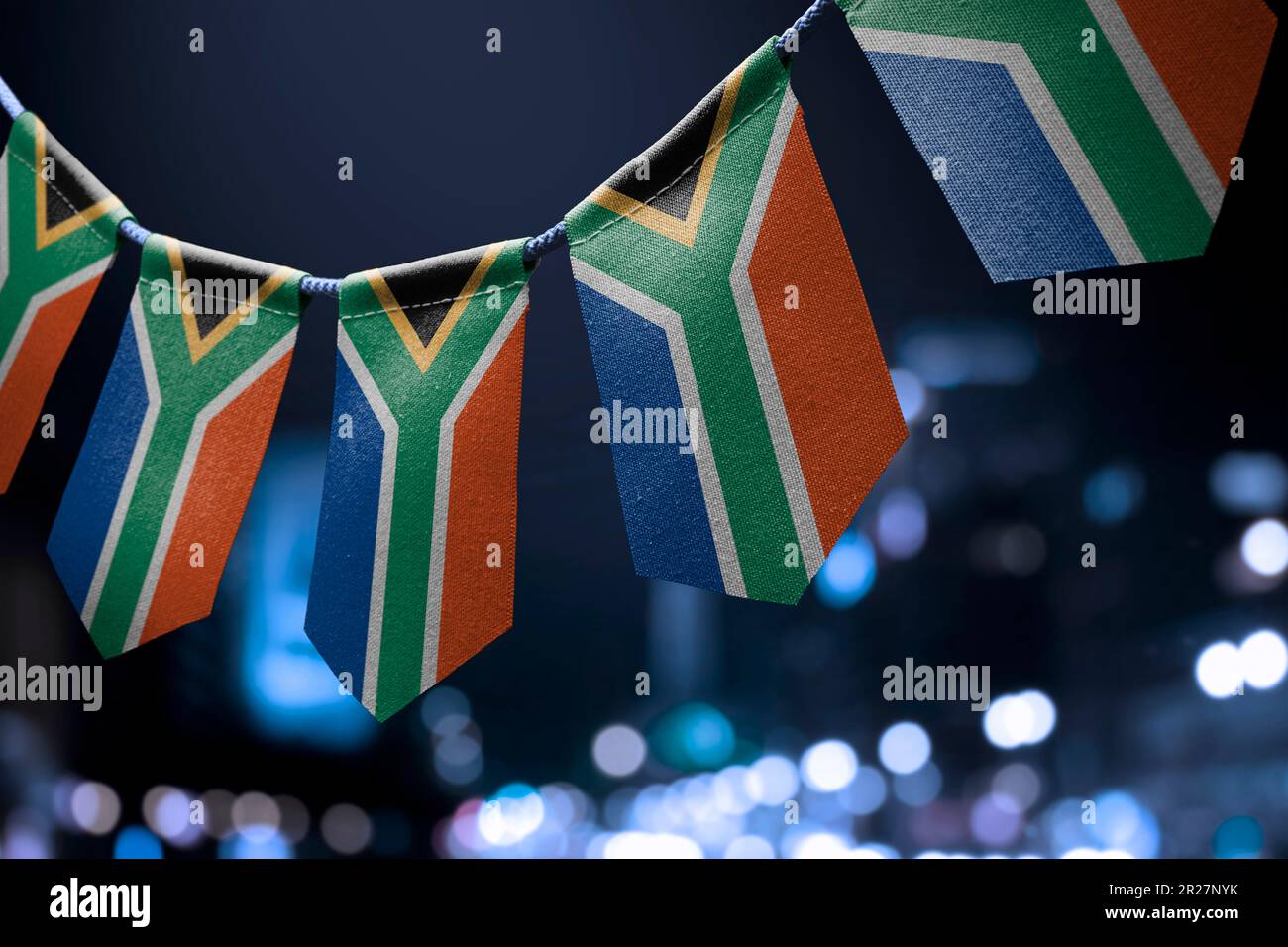 A garland of South Africa national flags on an abstract blurred ...
