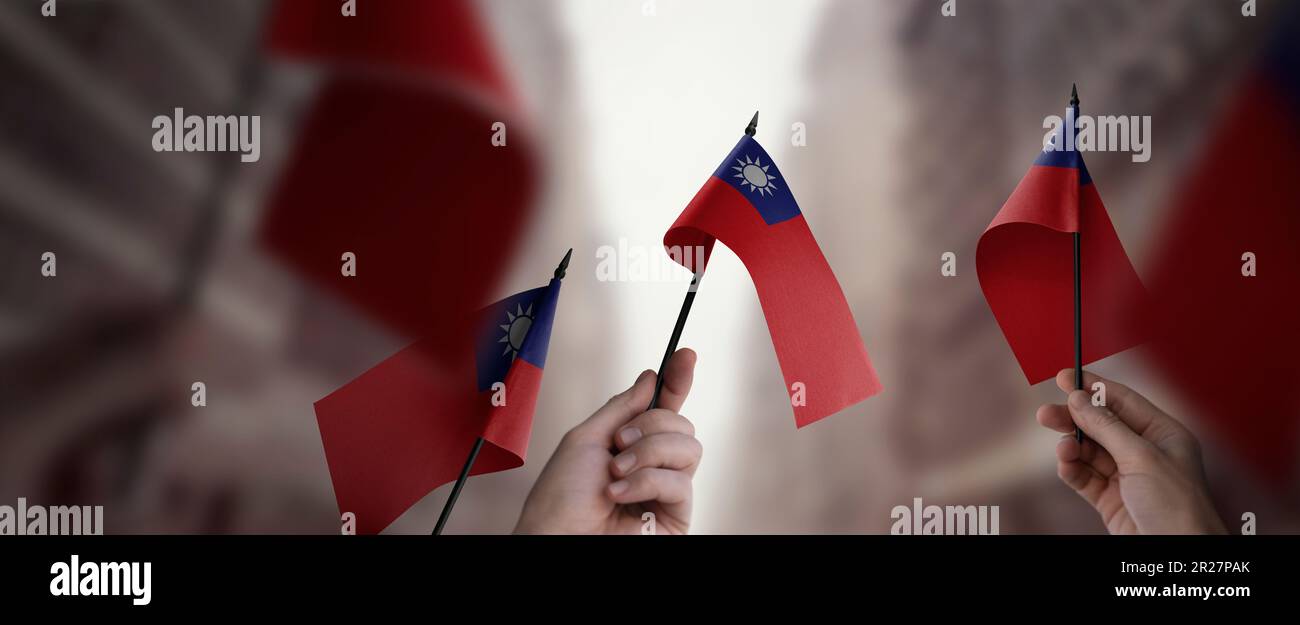 A group of people holding small flags of the Taiwan in their hands ...