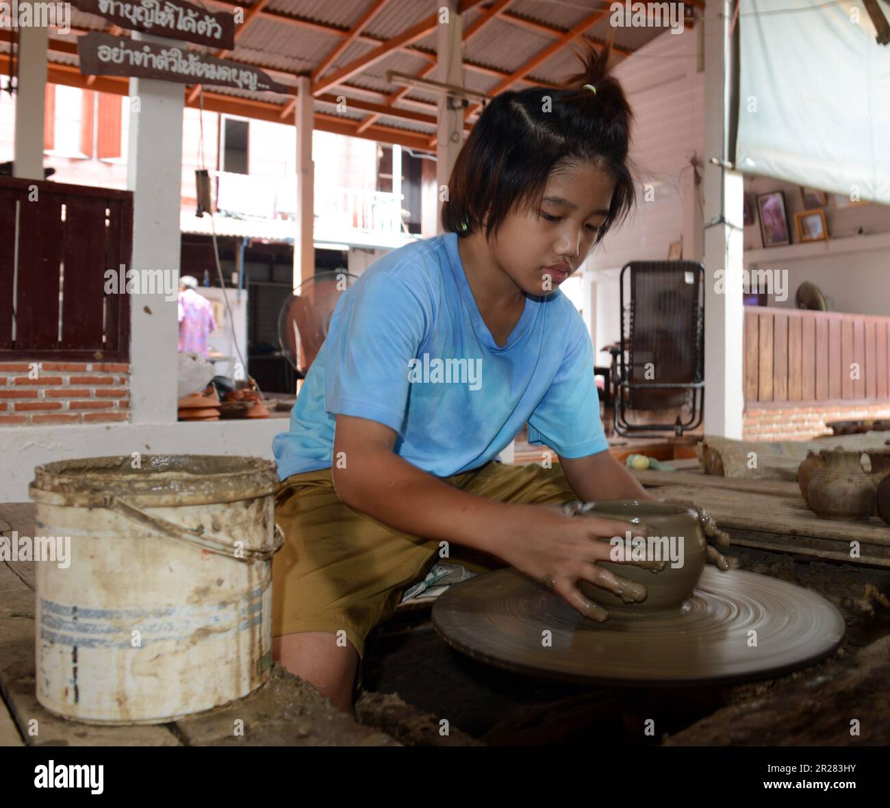A Thai girl practicing making pottery in a pottery workshop on Koh Kret ...