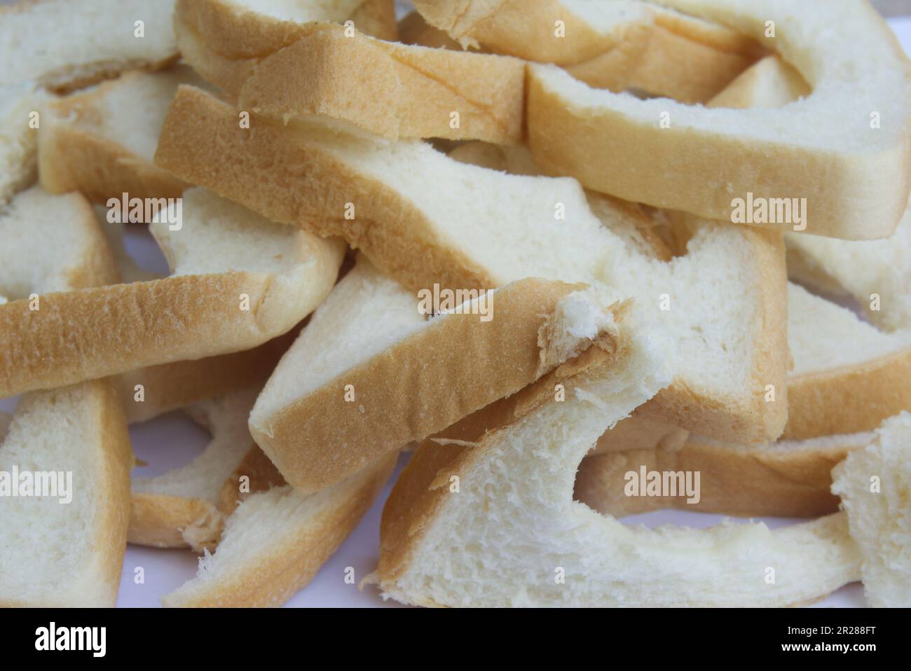 close up white bread crumbs. wasted food. edge of bread Stock Photo - Alamy