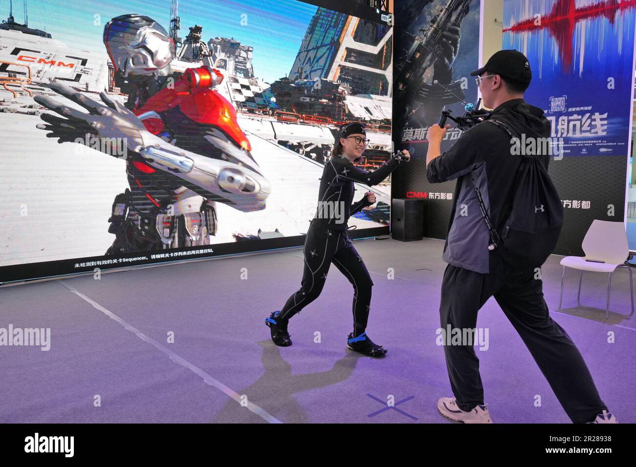 QINGDAO, CHINA - MAY 17, 2023 - A visitor (R) experiences motion ...
