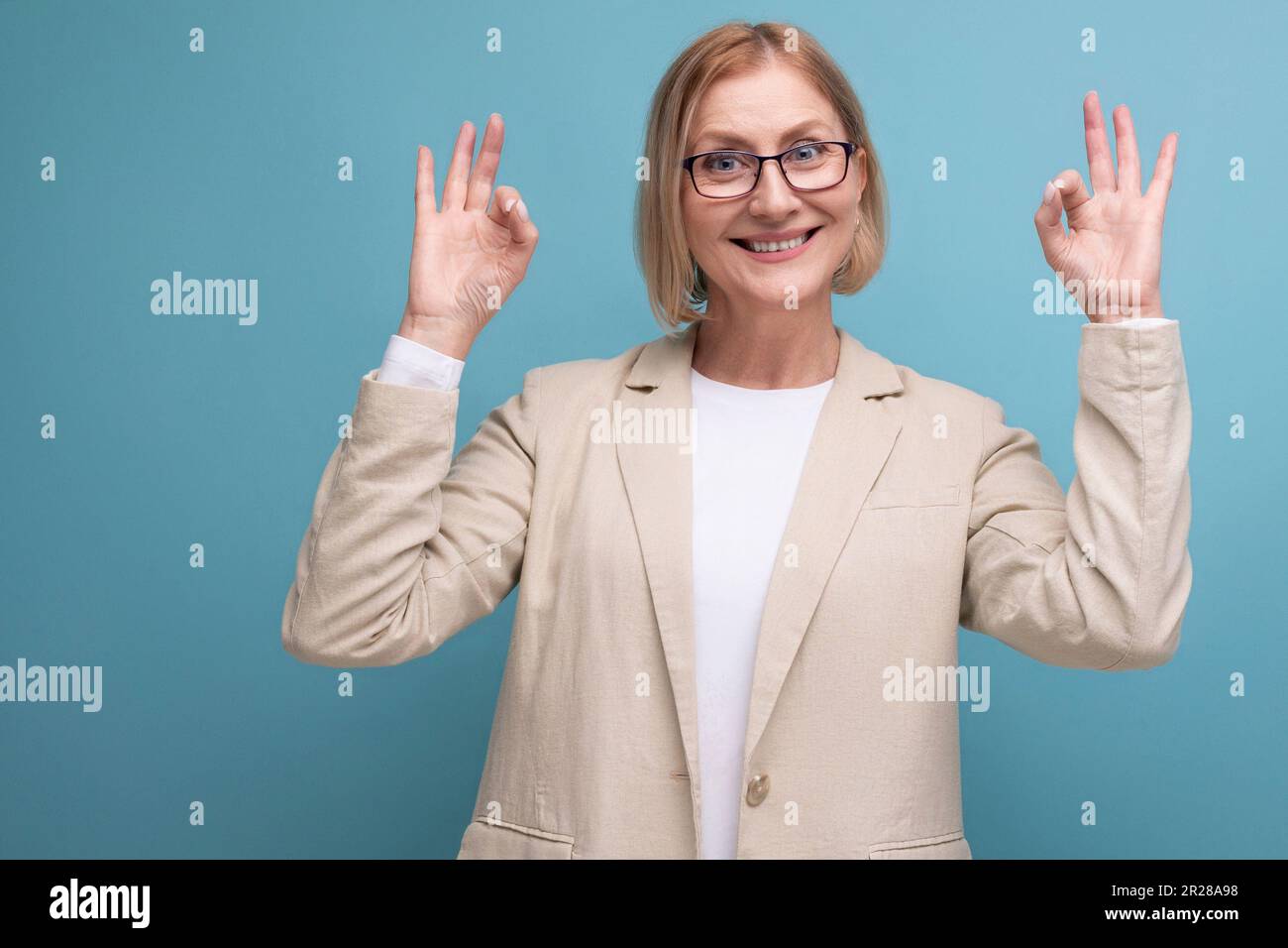 joyful smiling 50s mature woman smiling on plain background with copy ...