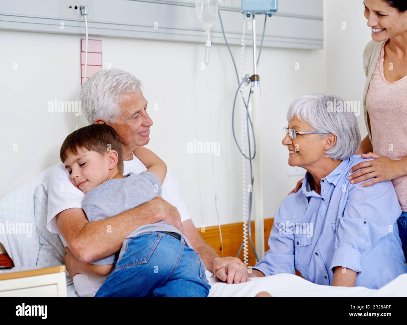The healing power of hugs. a sick man in a hospital bed getting a hug ...