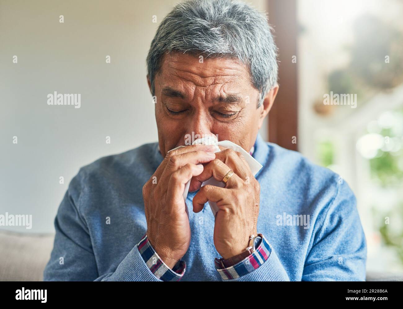 Senior man, sick and blowing nose in home from virus, allergy and ...