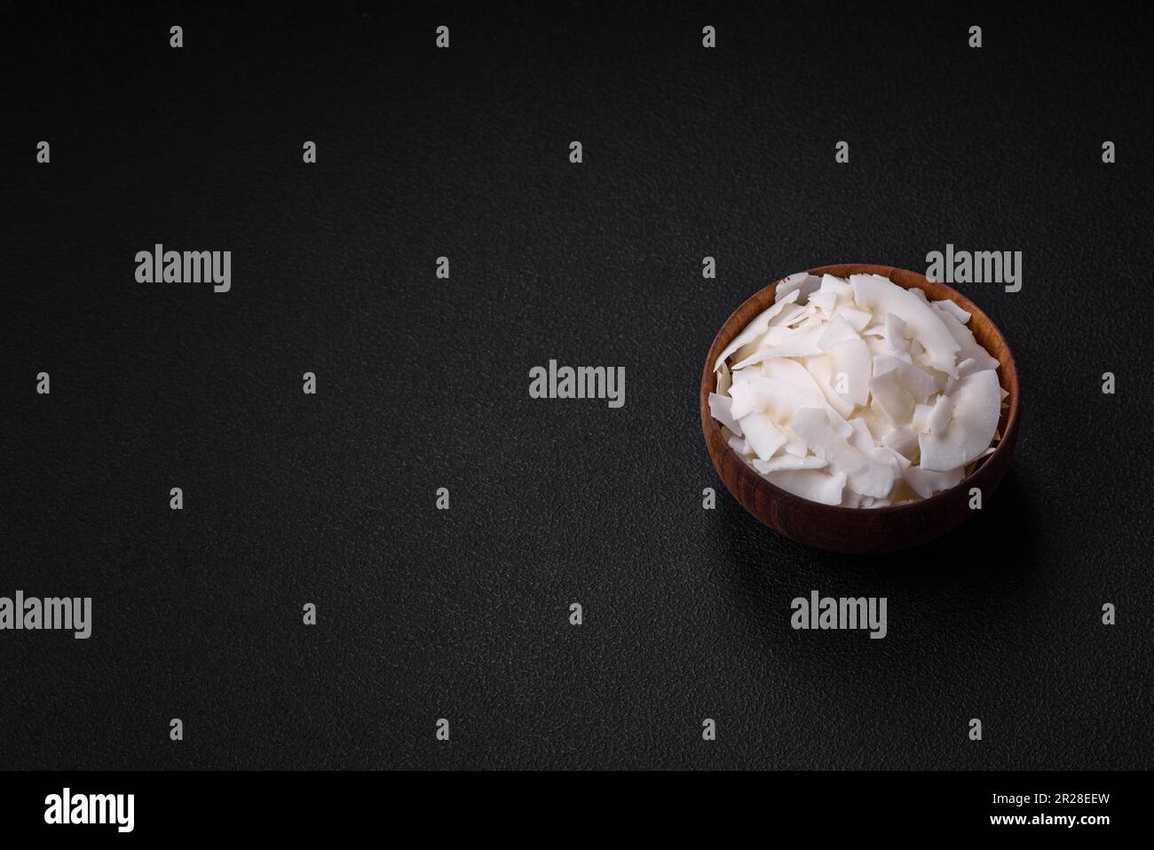 White dry coconut flakes in a wooden bowl prepared for making desserts ...