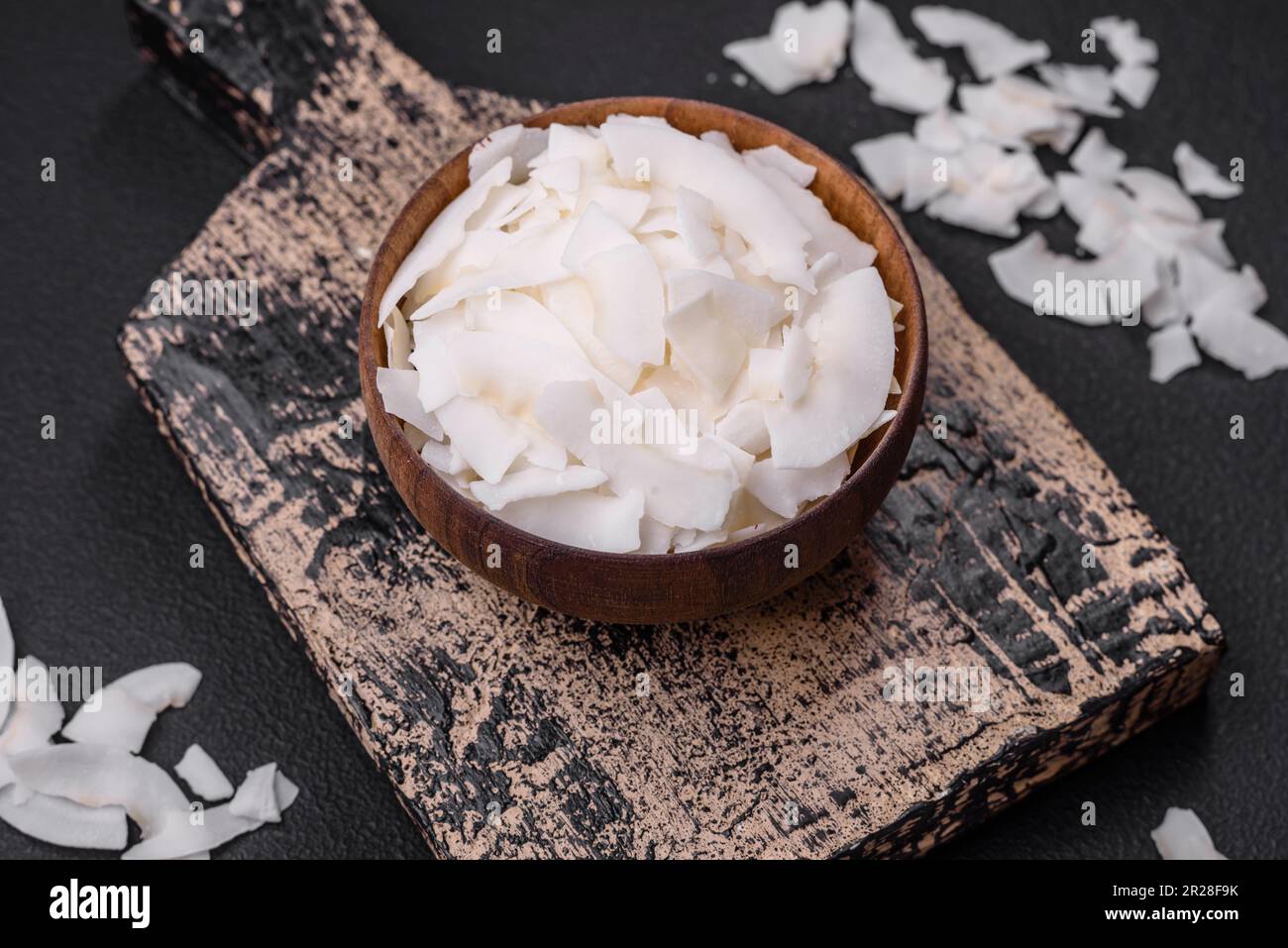 White dry coconut flakes in a wooden bowl prepared for making desserts ...