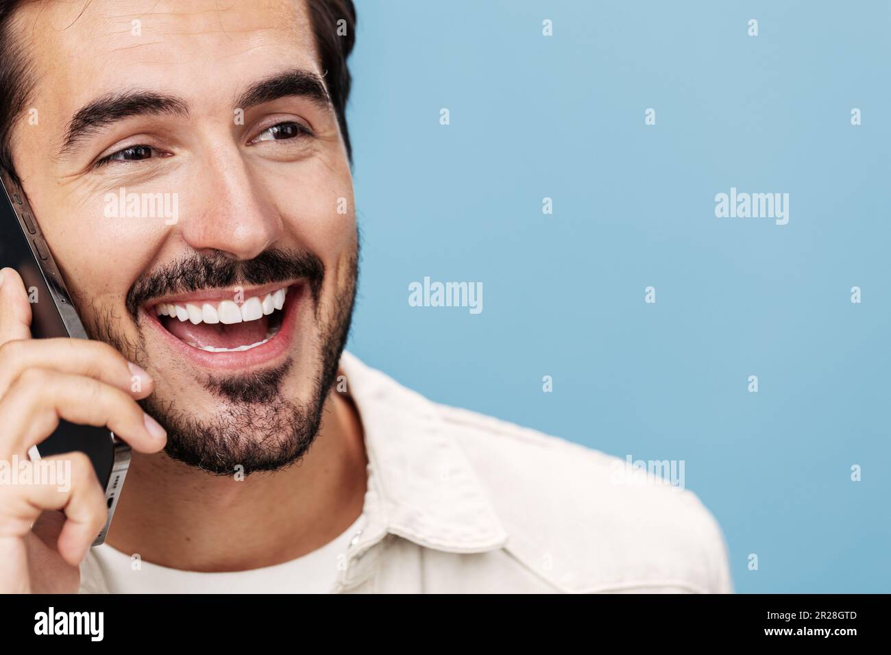 Close-up portrait of a brunette man talking on the phone, smile with ...