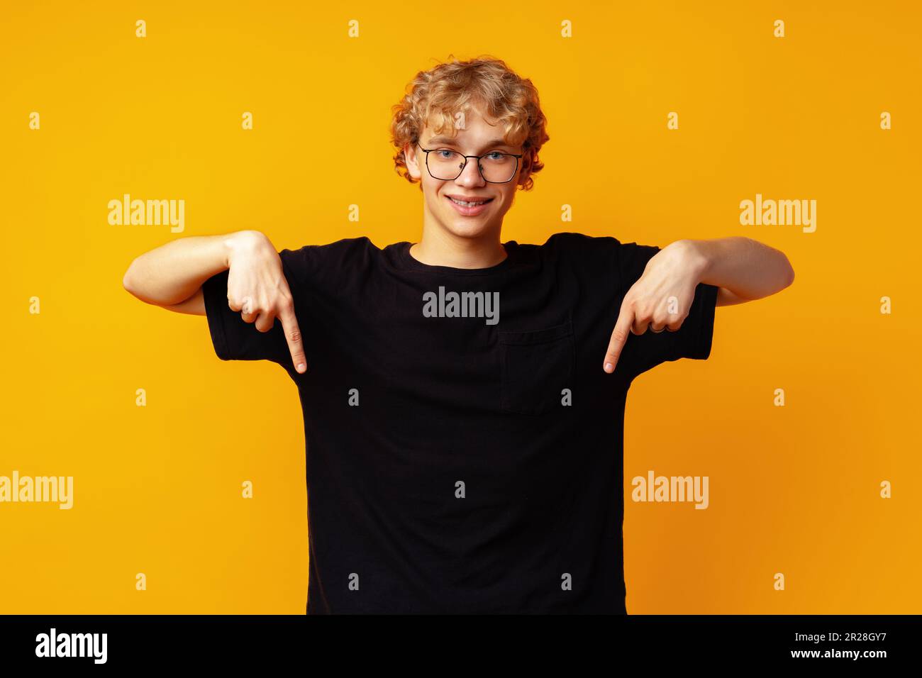 Young handsome man over yellow background pointing down fingers showing ...
