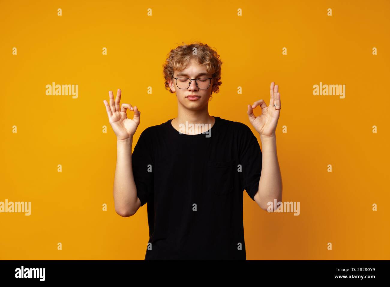 Handsome blonde man over yellow background in zen pose Stock Photo - Alamy