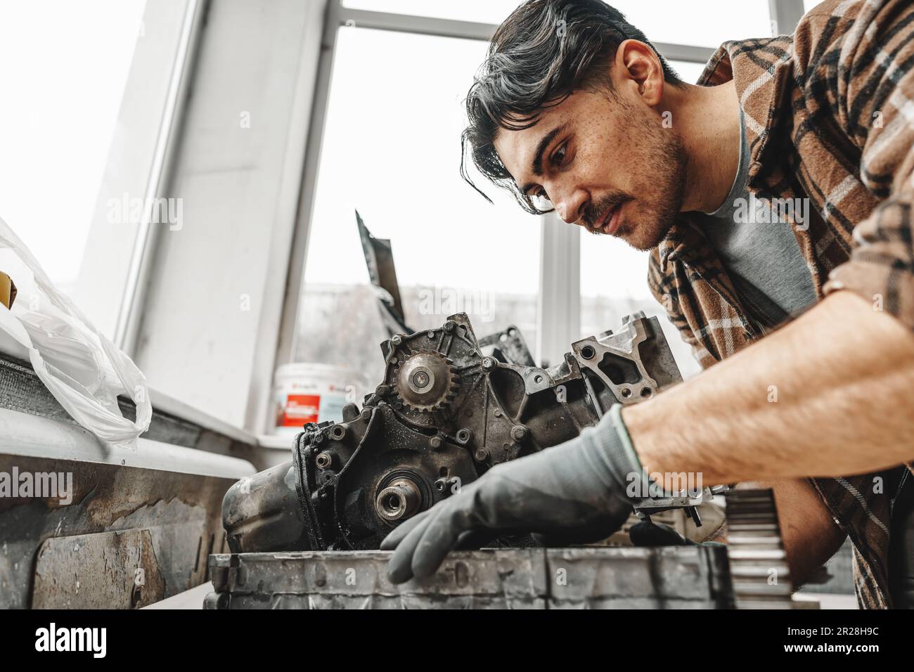 Workman disassembling car engine at the working table of the car service garage Stock Photo - Alamy