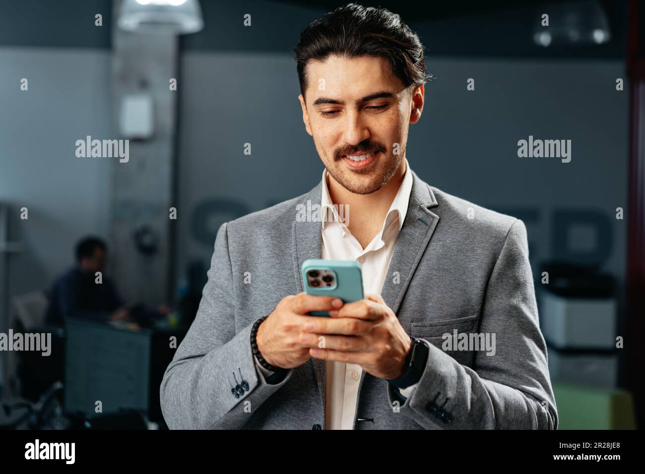 Handsome young arab man in formal wear using smartphone in office Stock ...