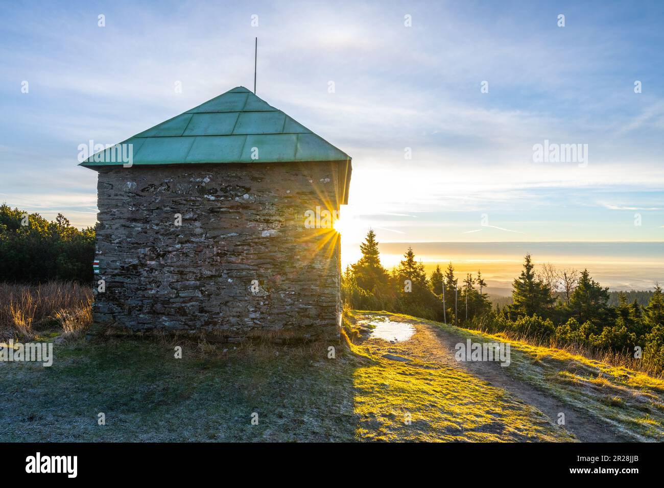 A frosty sunny morning with sun rays shining through a stone tourist ...