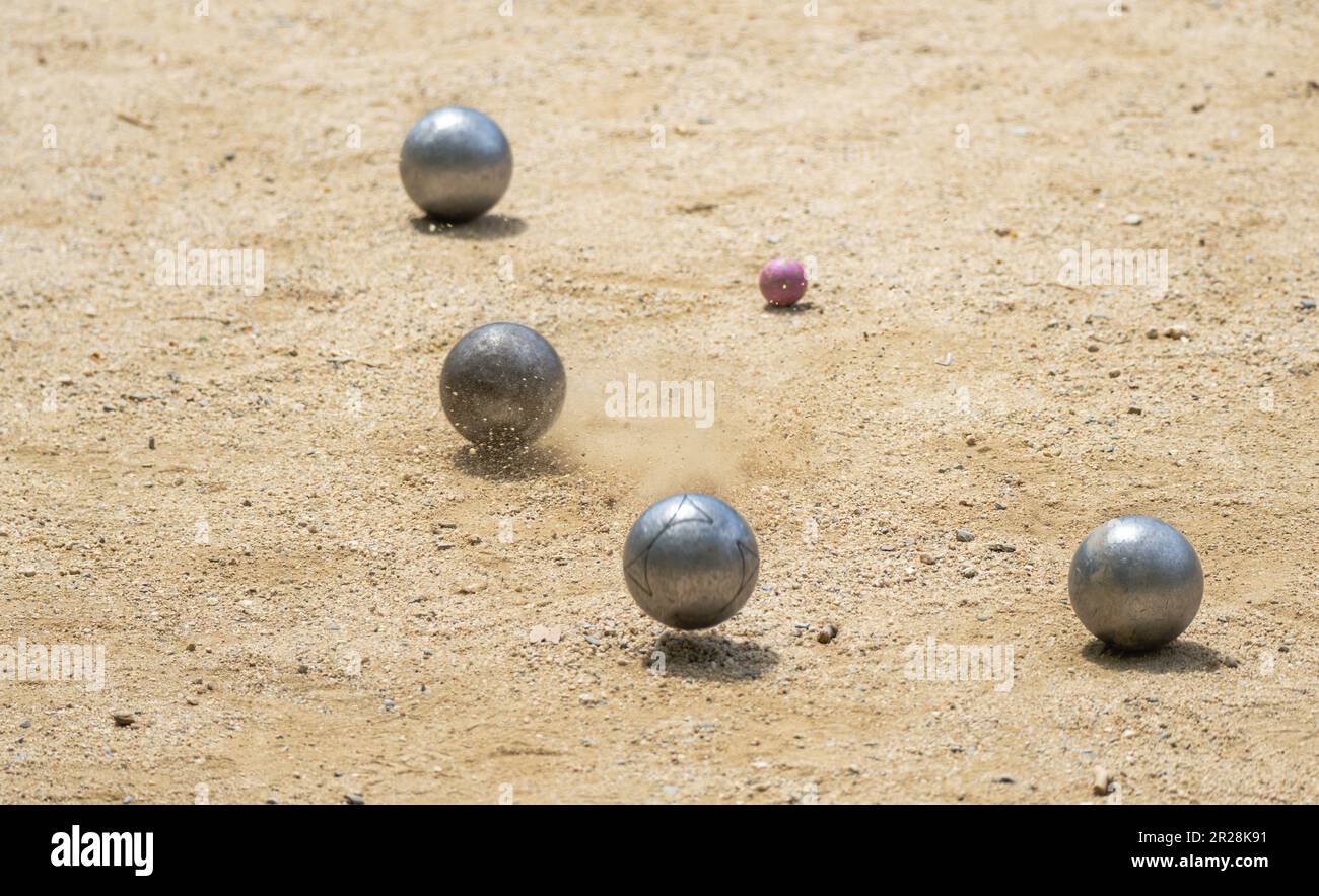 Metal ball from the game of petanque approaching the red bowling alley ...