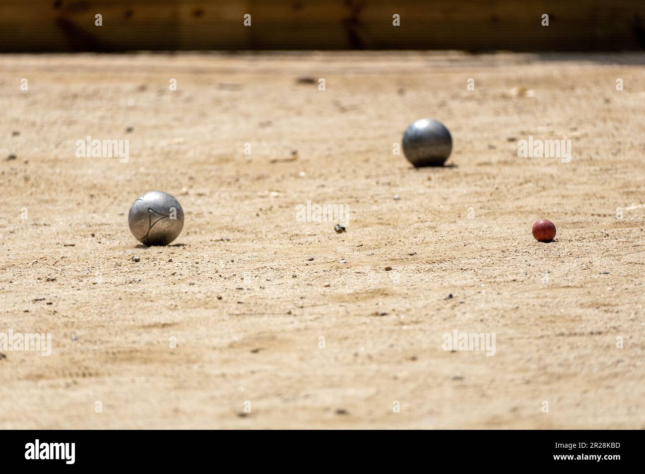 Two metal balls from the game of petanque approaching the bowling ball ...