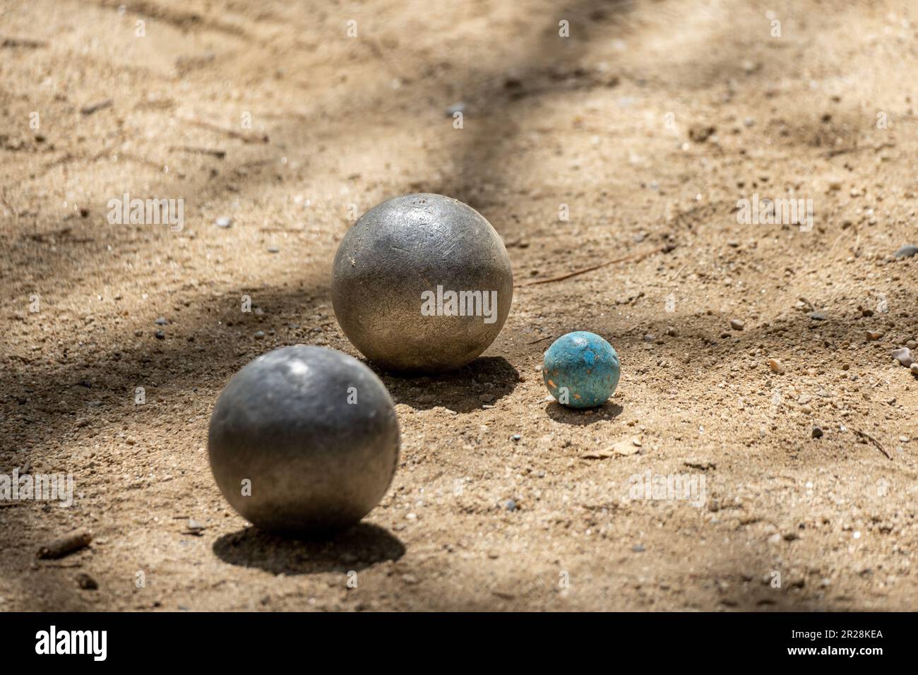 Two metal balls from the game of petanque approaching the bowling ball ...