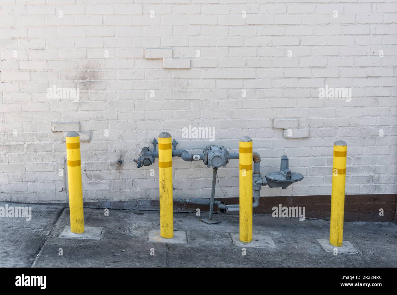 Striped bollards against brick wall with embossed bricks Stock Photo ...