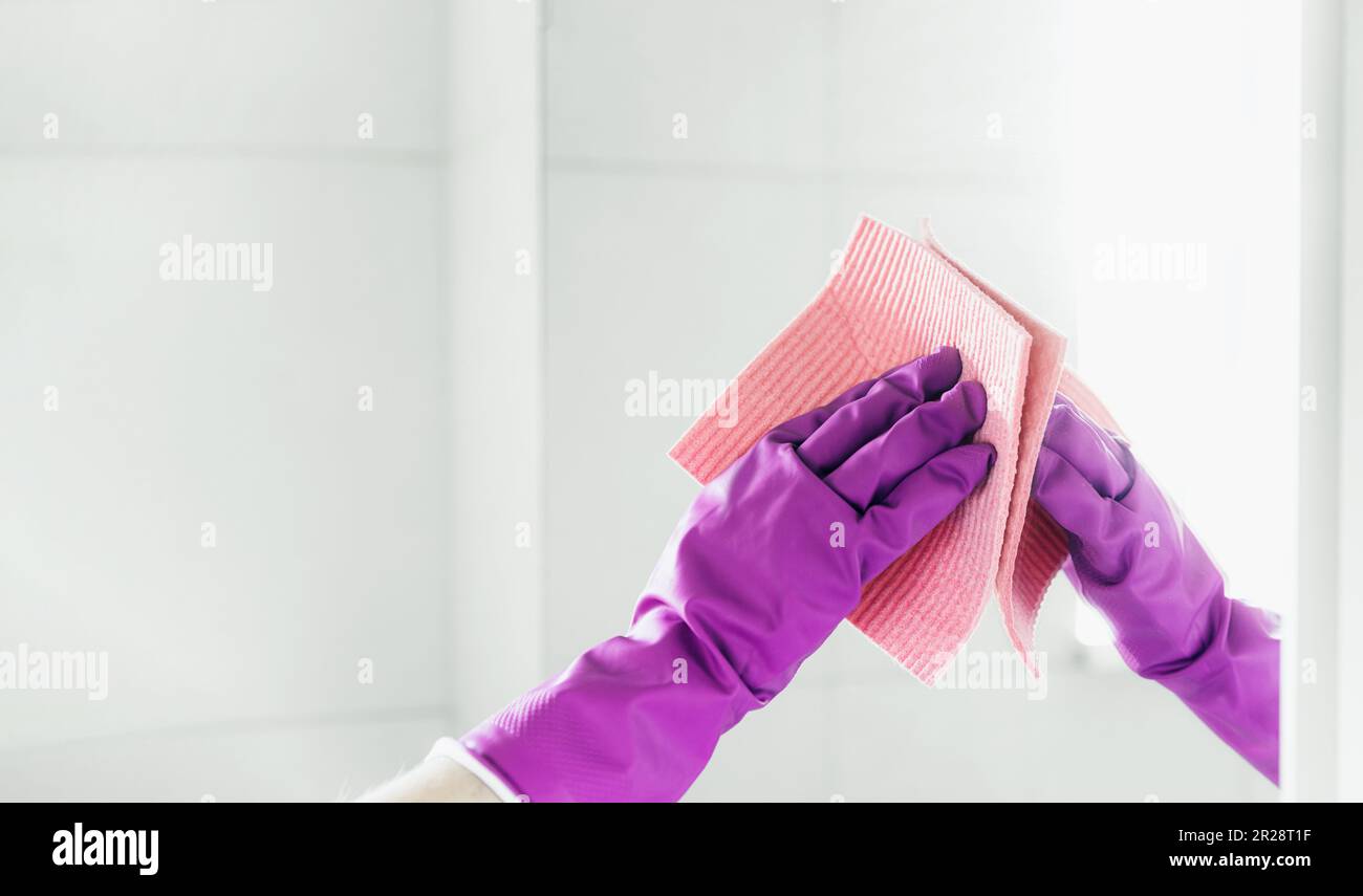 Cropped view of housekeeper woman hand in purple rubber gloves ...