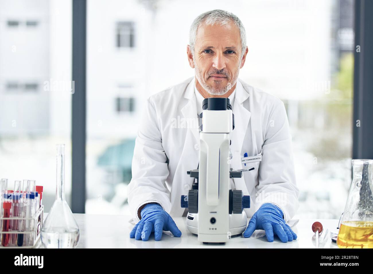Man, microscope and portrait of scientist in science research, breakthrough or discovery at the ...