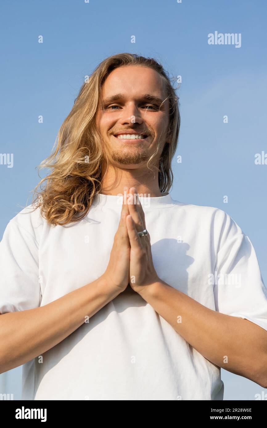 Praying hands against blue sky hi-res stock photography and images - Alamy
