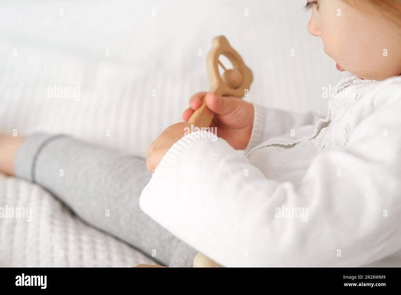 Cute baby girl playing tactile wooden and silicone toys. Young child ...